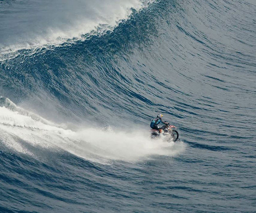 Australian surfer catches a wave on a motorbike